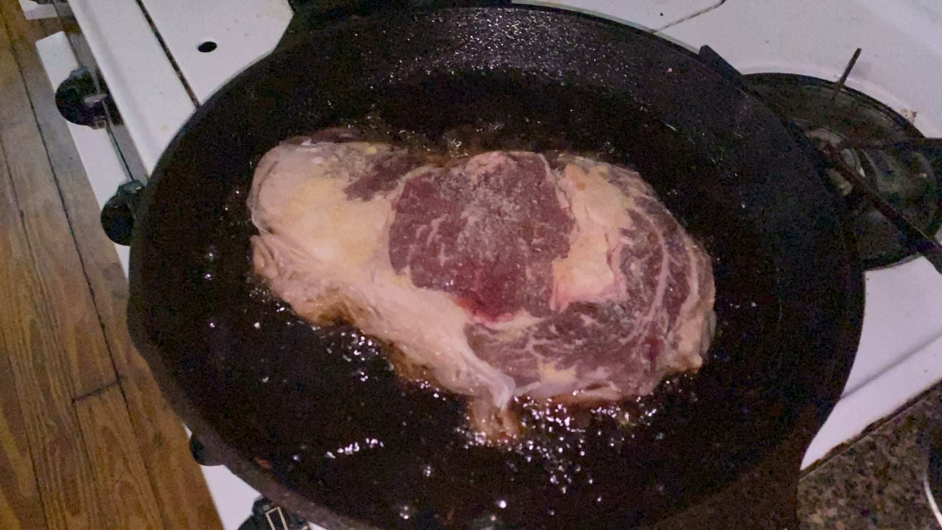 Flipping a one kilogram steak aged 60 days in bacon lard in a large ...