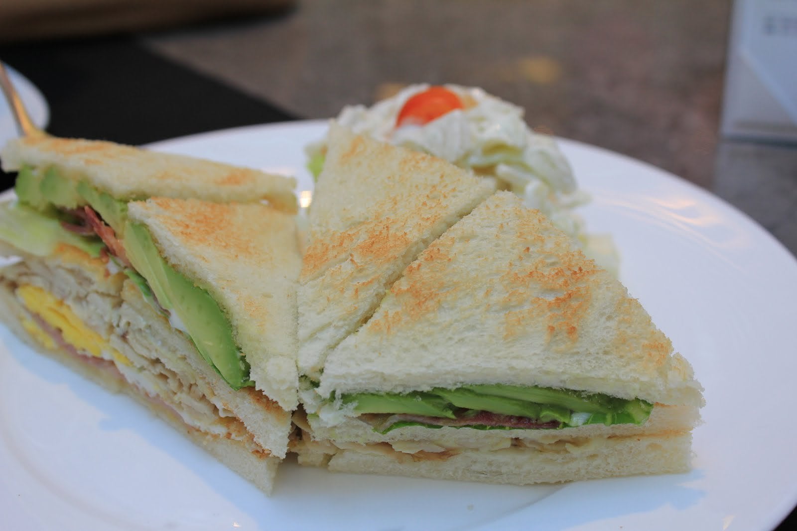 Club sandwich with ham, egg, turkey breast, bacon, avocado (from bottom ...