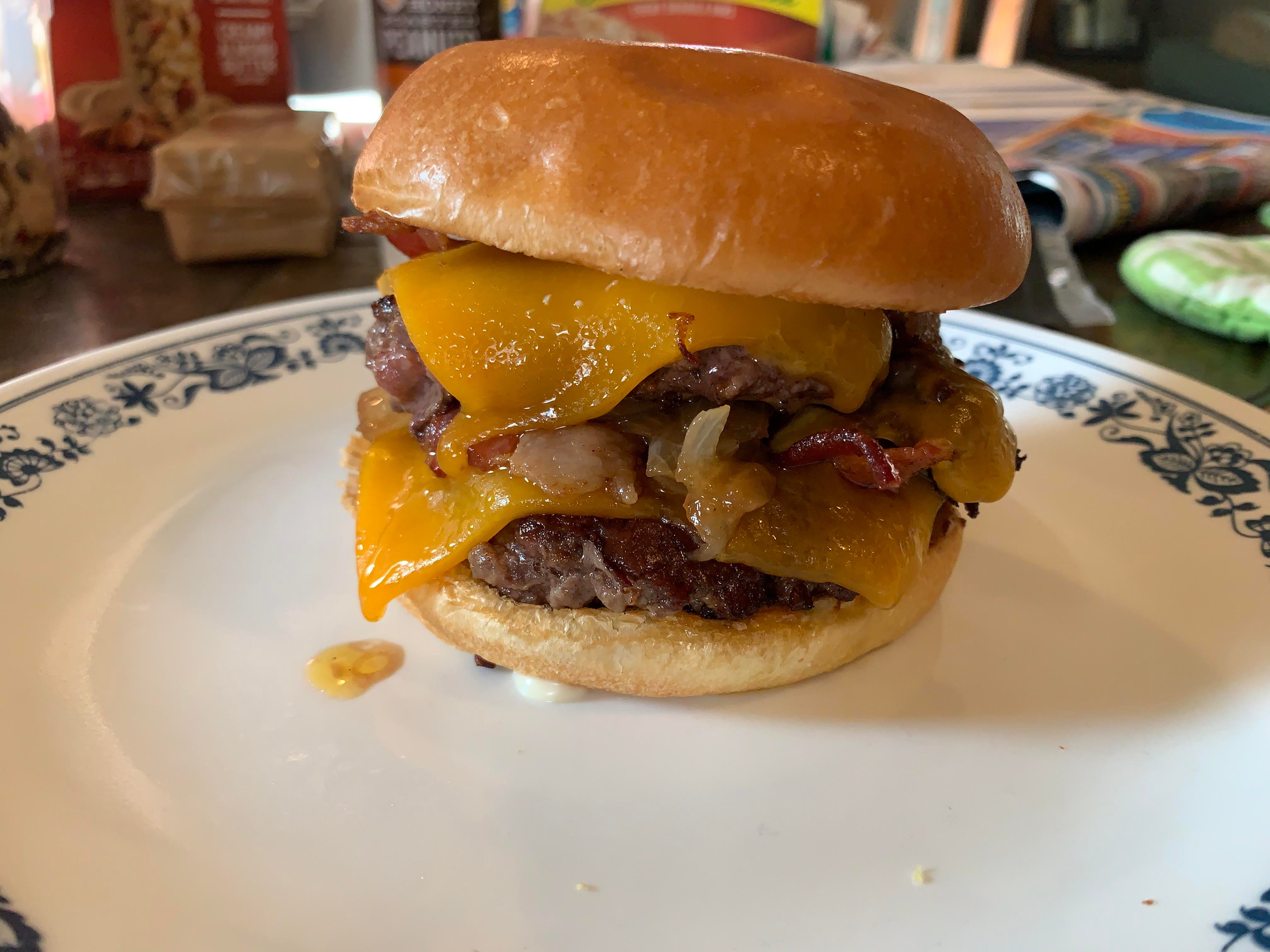 Double smash burger with cheddar, bacon, caramelized onions on brioche ...