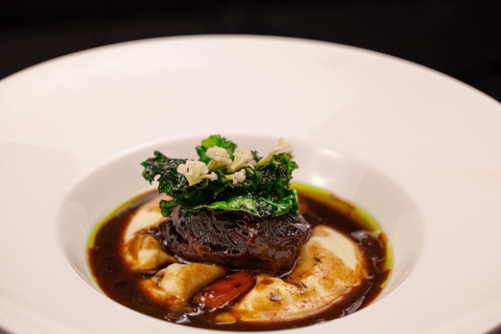 Braised beef cheek, cauliflower purée, crispy kale and pickled caulini ...