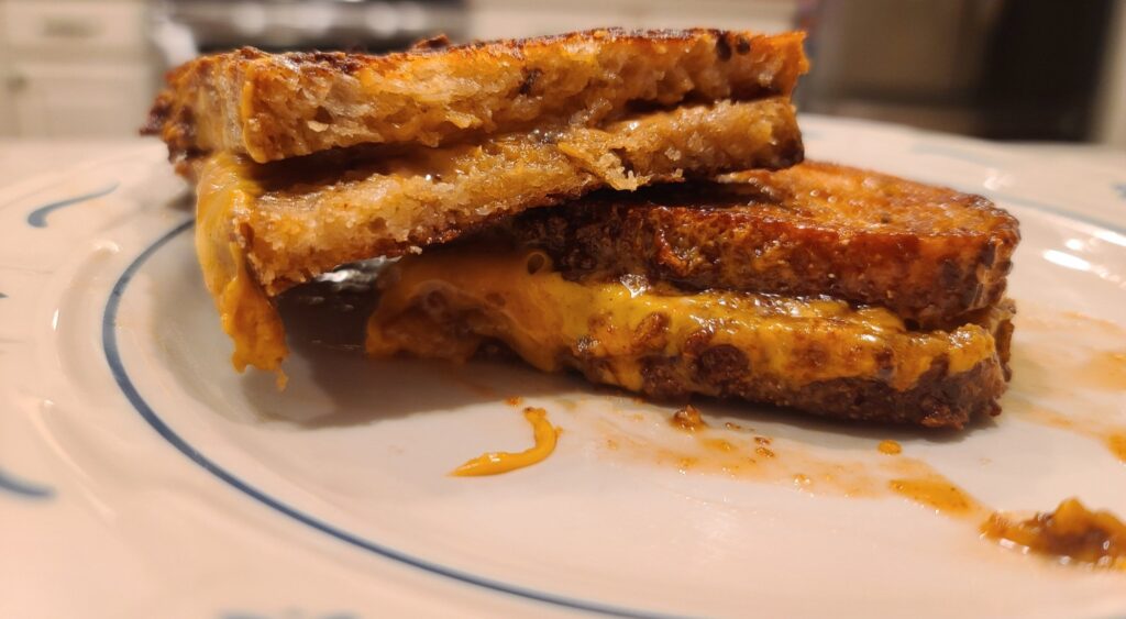 Peanut butter, honey, and american cheese on deli whole grain bread pan ...