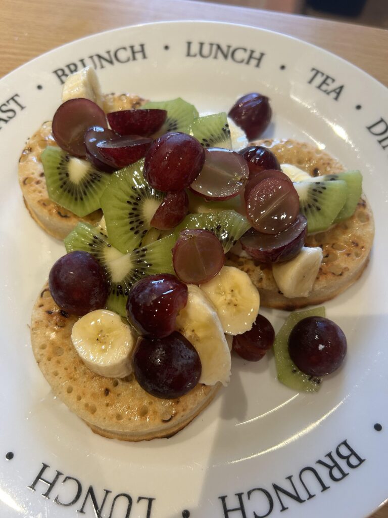 Toasted crumpets with kiwi, banana and grapes. Loads of butter on the ...