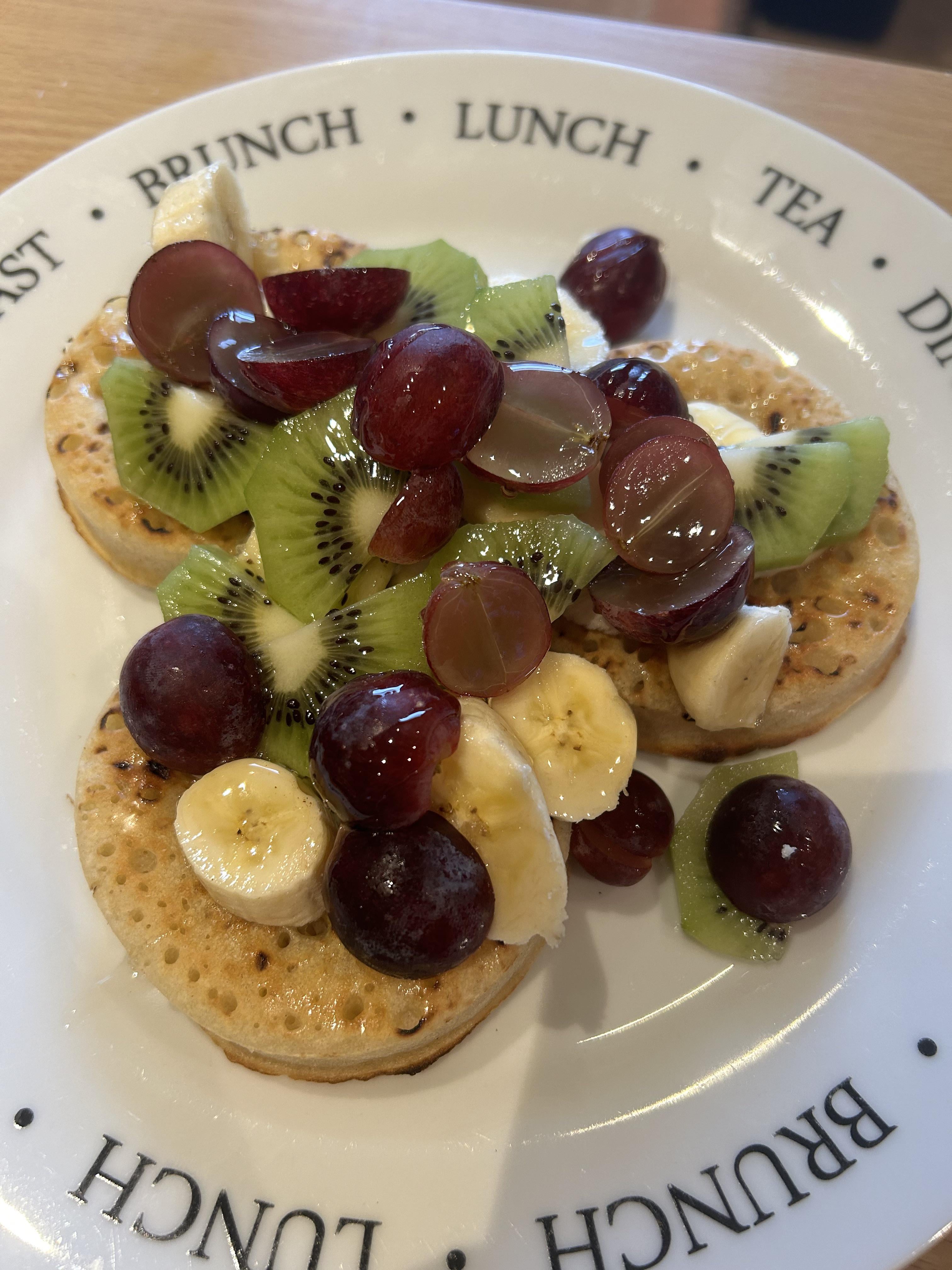 Toasted crumpets with kiwi, banana and grapes. Loads of butter on the ...