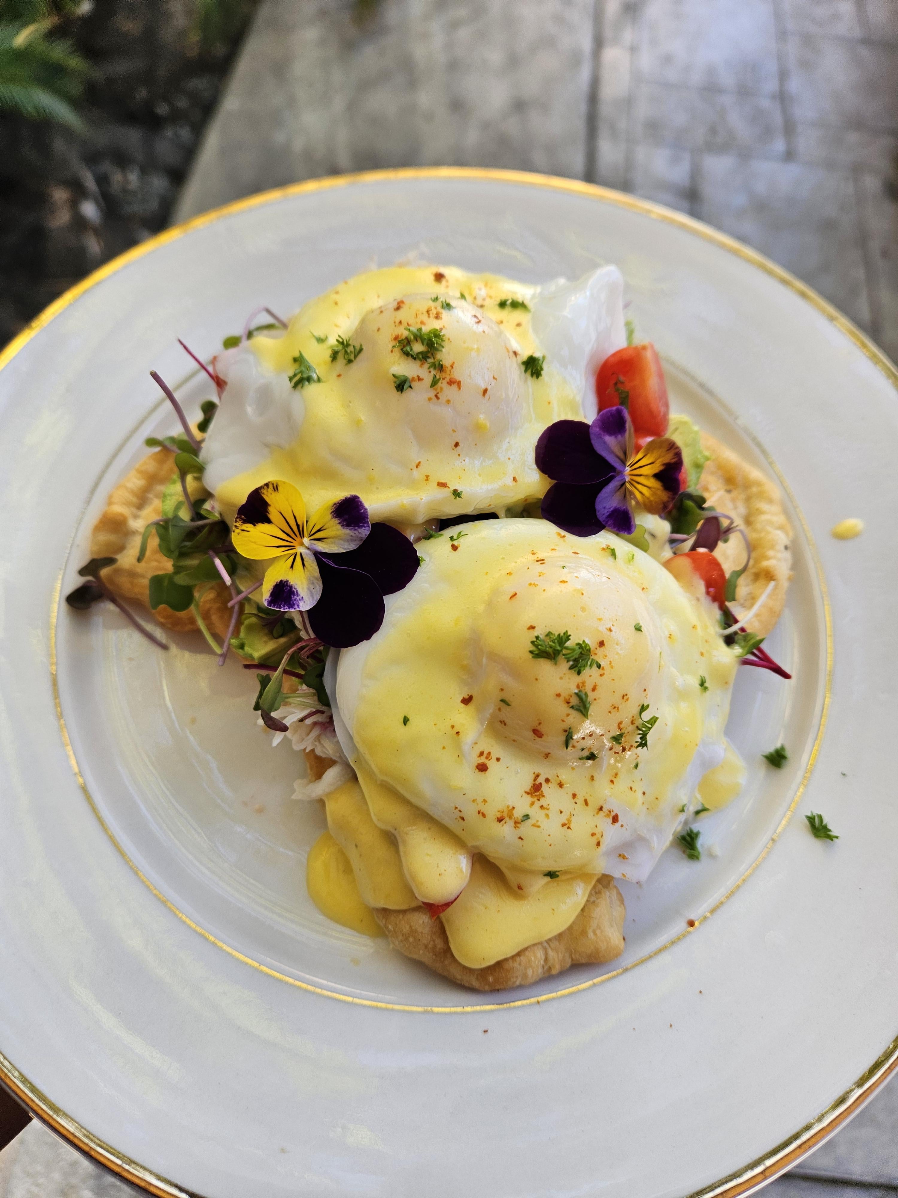 Crab benedict with avocado, micro-greens and garden tomatoes on a ...