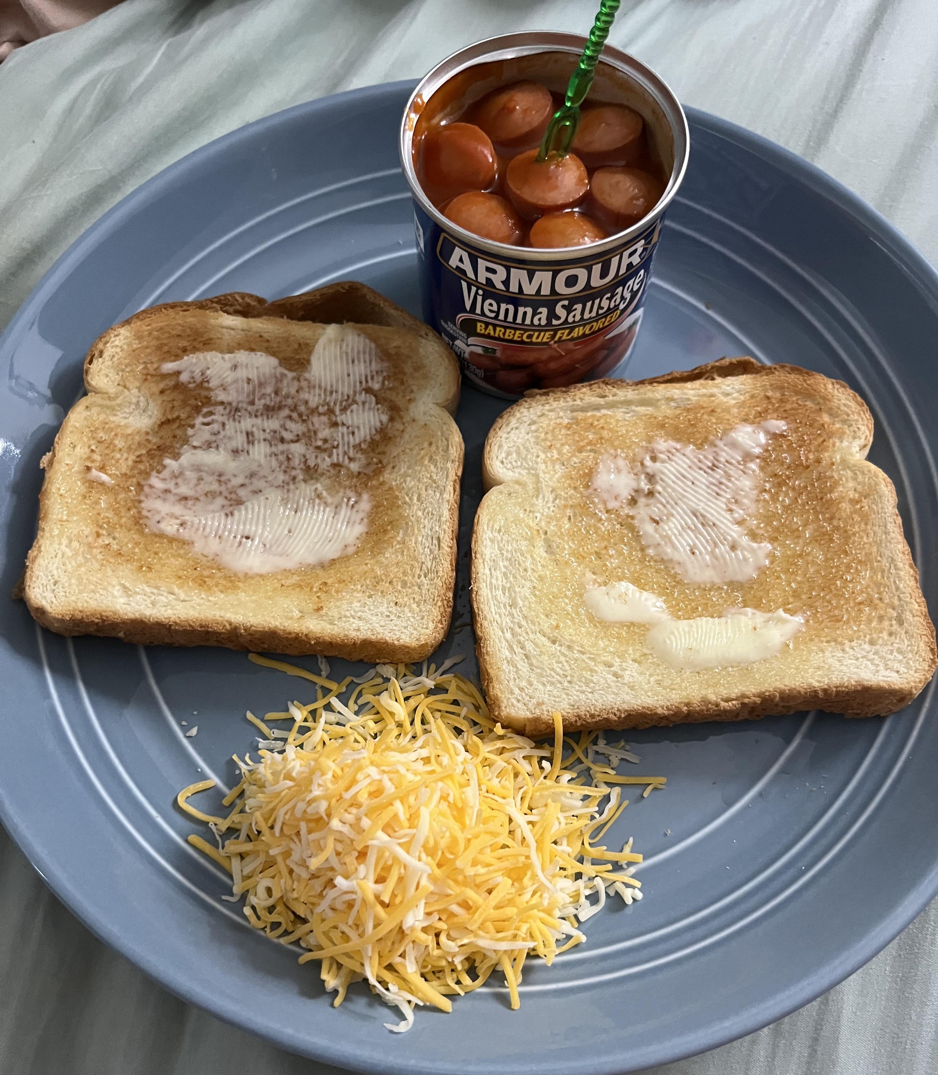 BBQ Vienna sausages, buttered toast, and shredded cheese. Consumed in ...