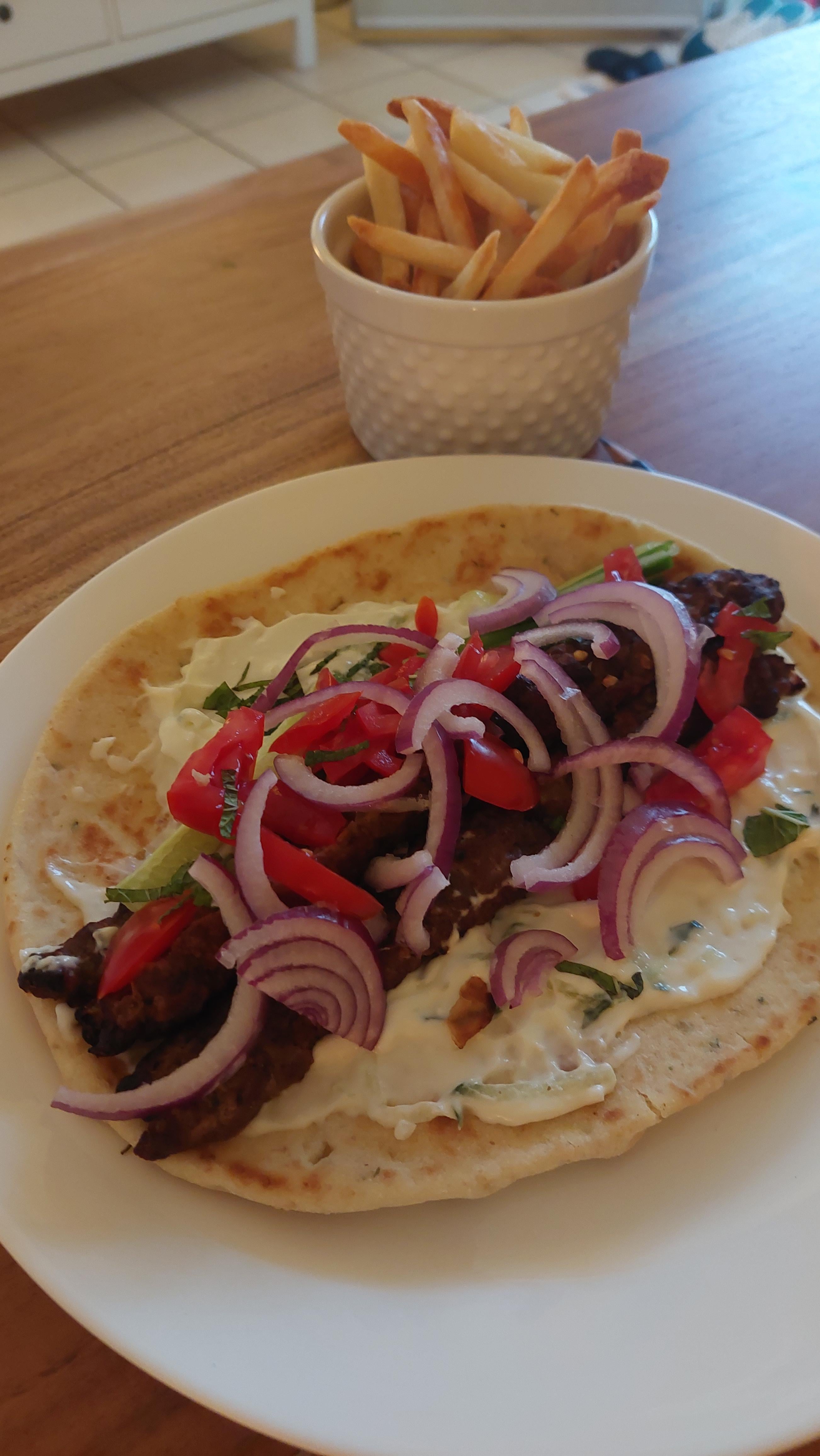 Chicken kebabs wrap on naan with tzaziki, tomato, cucumber, onion, mint ...